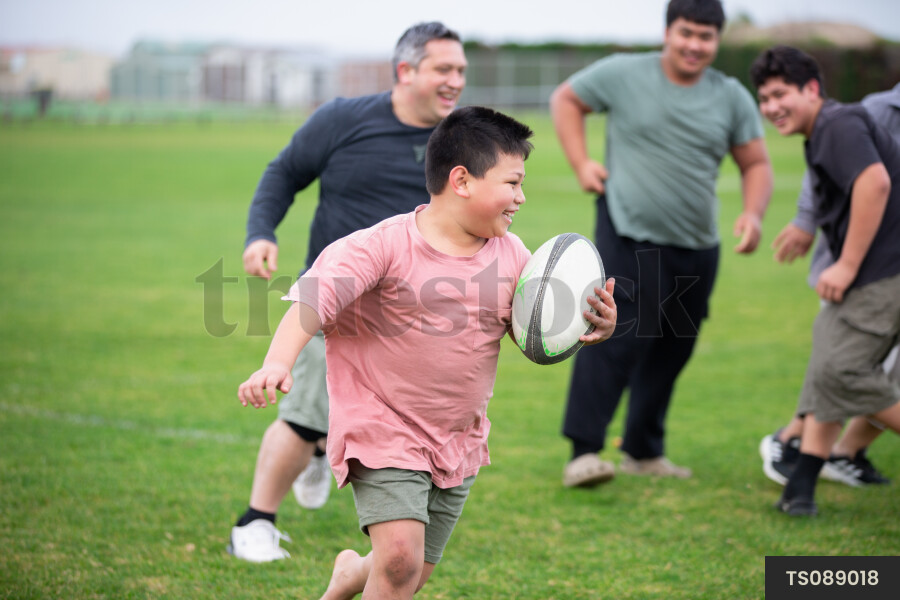 Family Playing Rugby at School Field by Emma Diack - Truestock