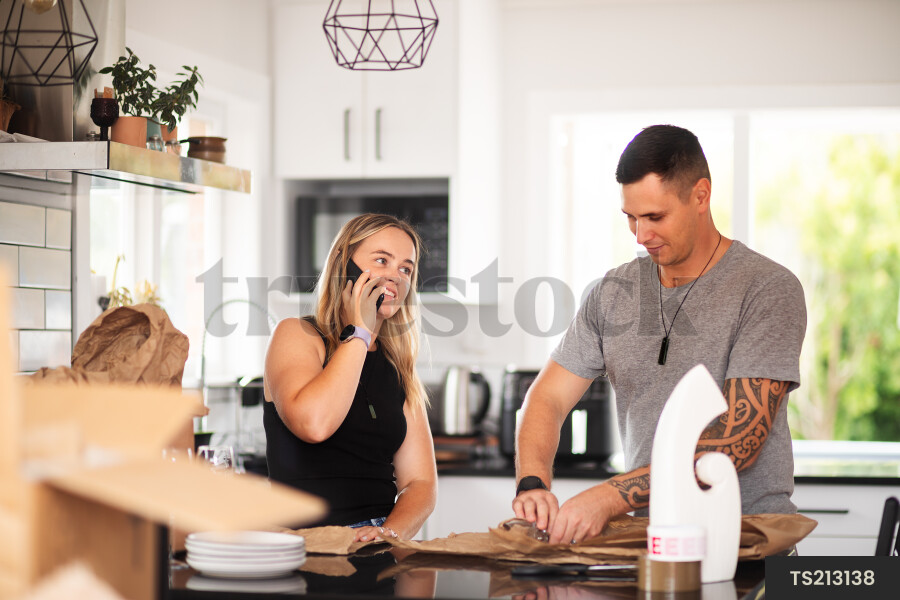 Couple packing in kitchen by Salena Stinchcombe - Truestock
