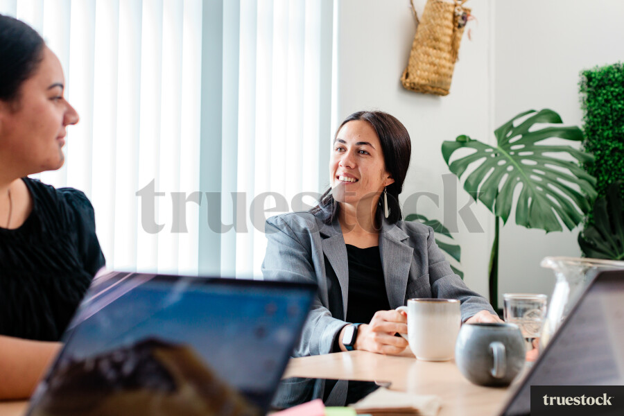 Colleagues Having Discussion in Meeting by Erica Sinclair - Truestock