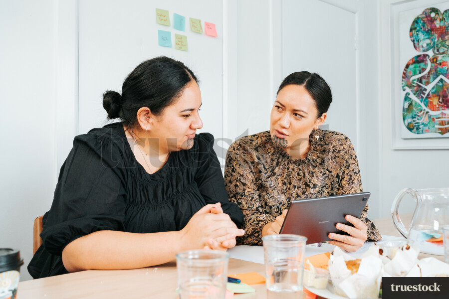 Women Using Tablet During Meeting by Ngahuia Ormsby - Truestock