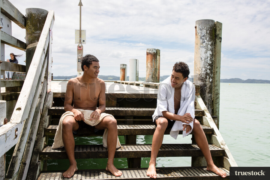 Teen Boys Sitting on Wharf by Emma Diack - Truestock