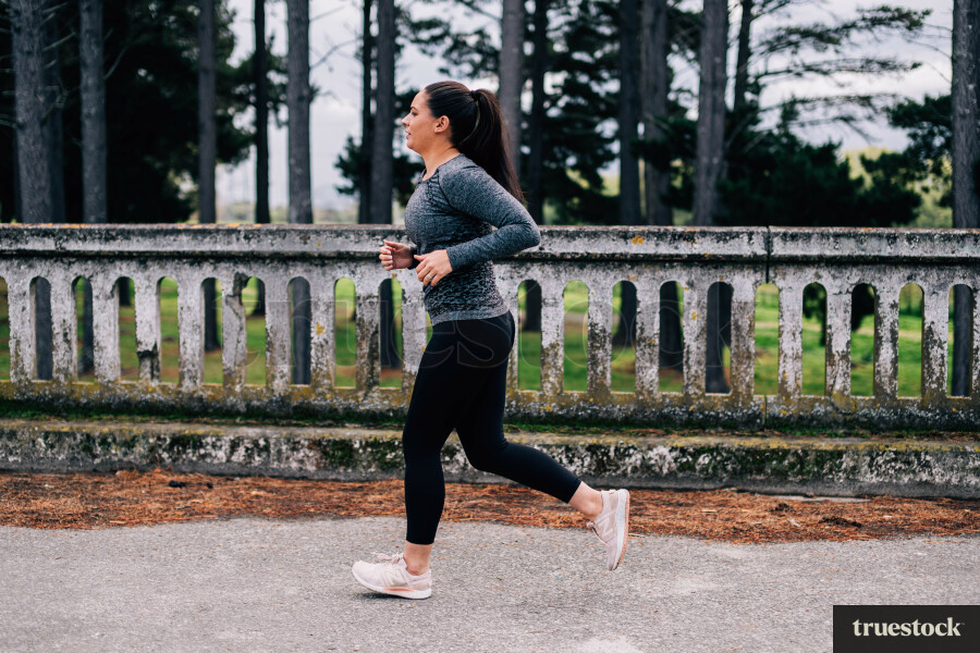 Woman in activewear running by Michael Farr - Truestock