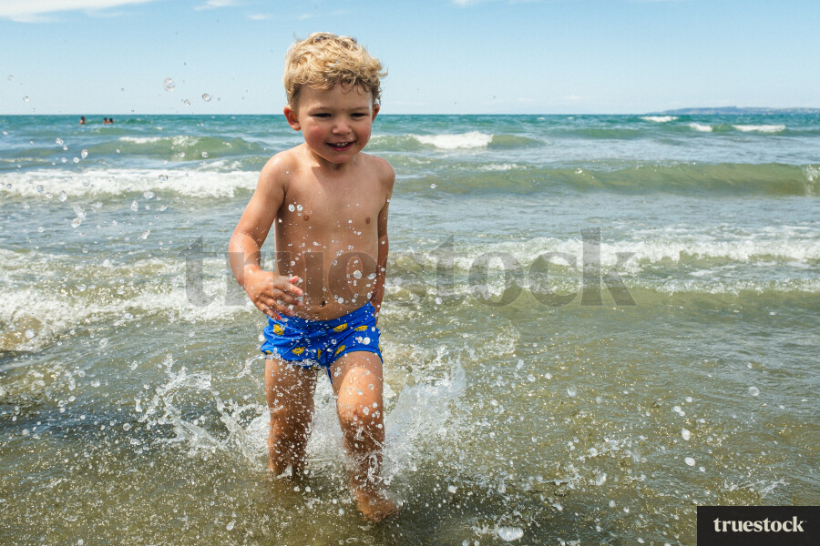 Child Playing in the Ocean by David Marano - Truestock