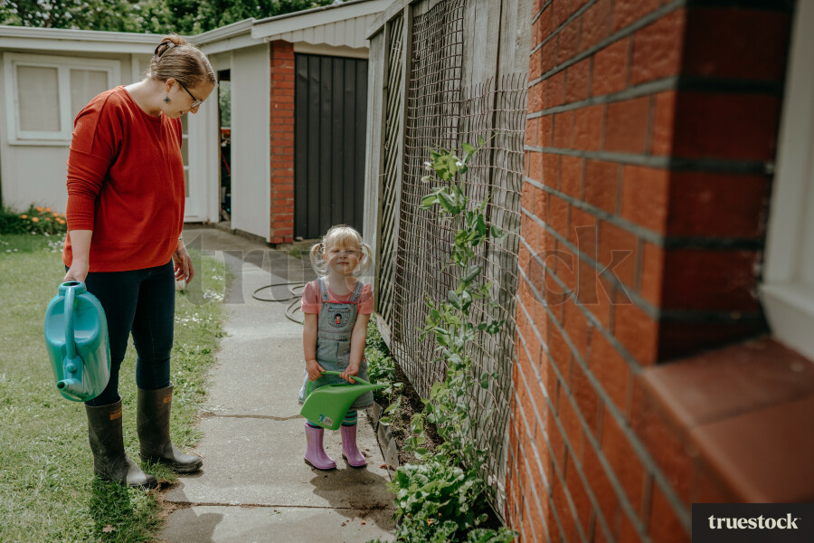 Girl watering plants by Liz Robson - Truestock