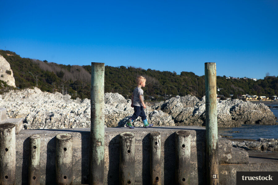 Child walking down a boat ramp to the water by Kathryn Taylor - Truestock