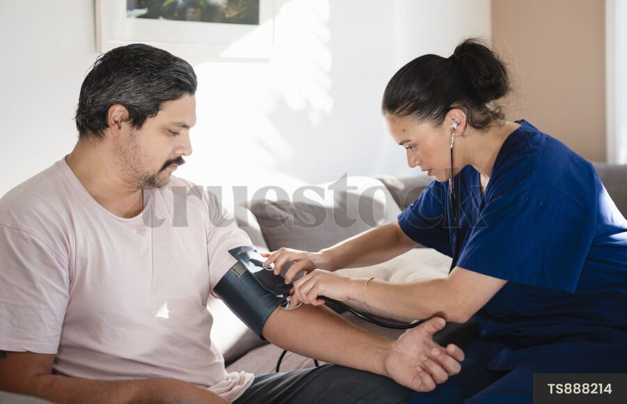 Nurse taking blood pressure of patient by Jeremy Town - Truestock