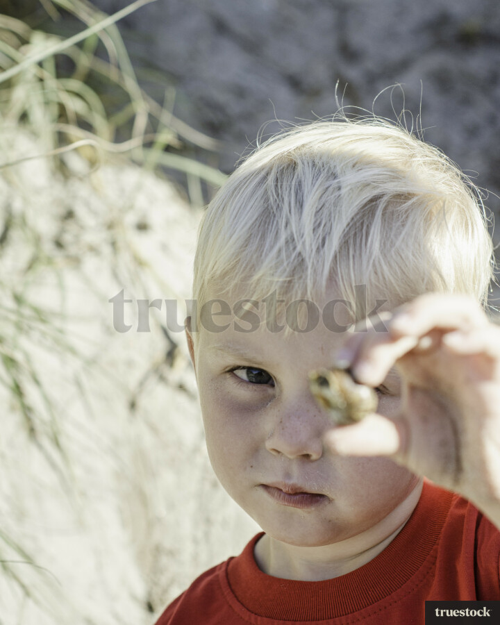 Young Boy Holding Snail by Jay Drew - Truestock