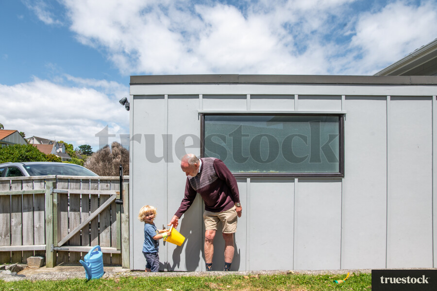 Grandfather Passing Grandkid a Bucket by James Stonley - Truestock